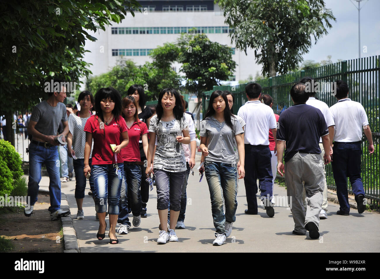 Chinese Foxconn employees walk in the Shenzhen plant of Foxconn ...