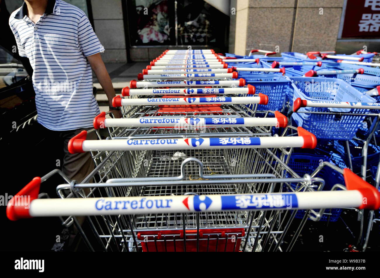 --FILE--A customer walks past shopping carts outside a Carrefour ...