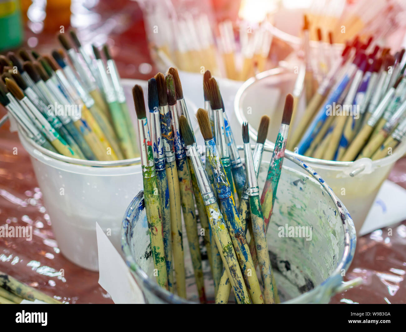 Artist paint brushes. Many artist tools in plastic bucket, art ...