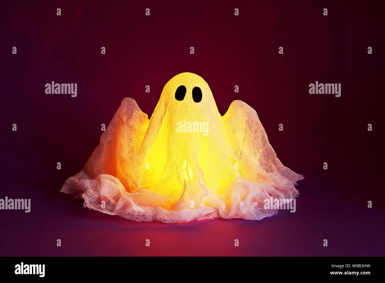 Halloween ghost of starch and gauze on ultraviolet background. Gift ...