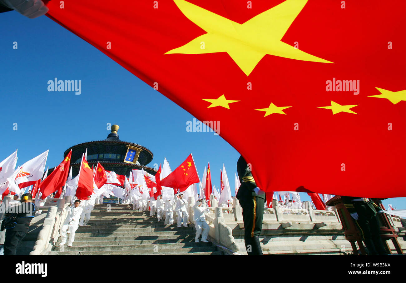 Chinese paramilitary policemen hold a Chinese flag during the torch ...
