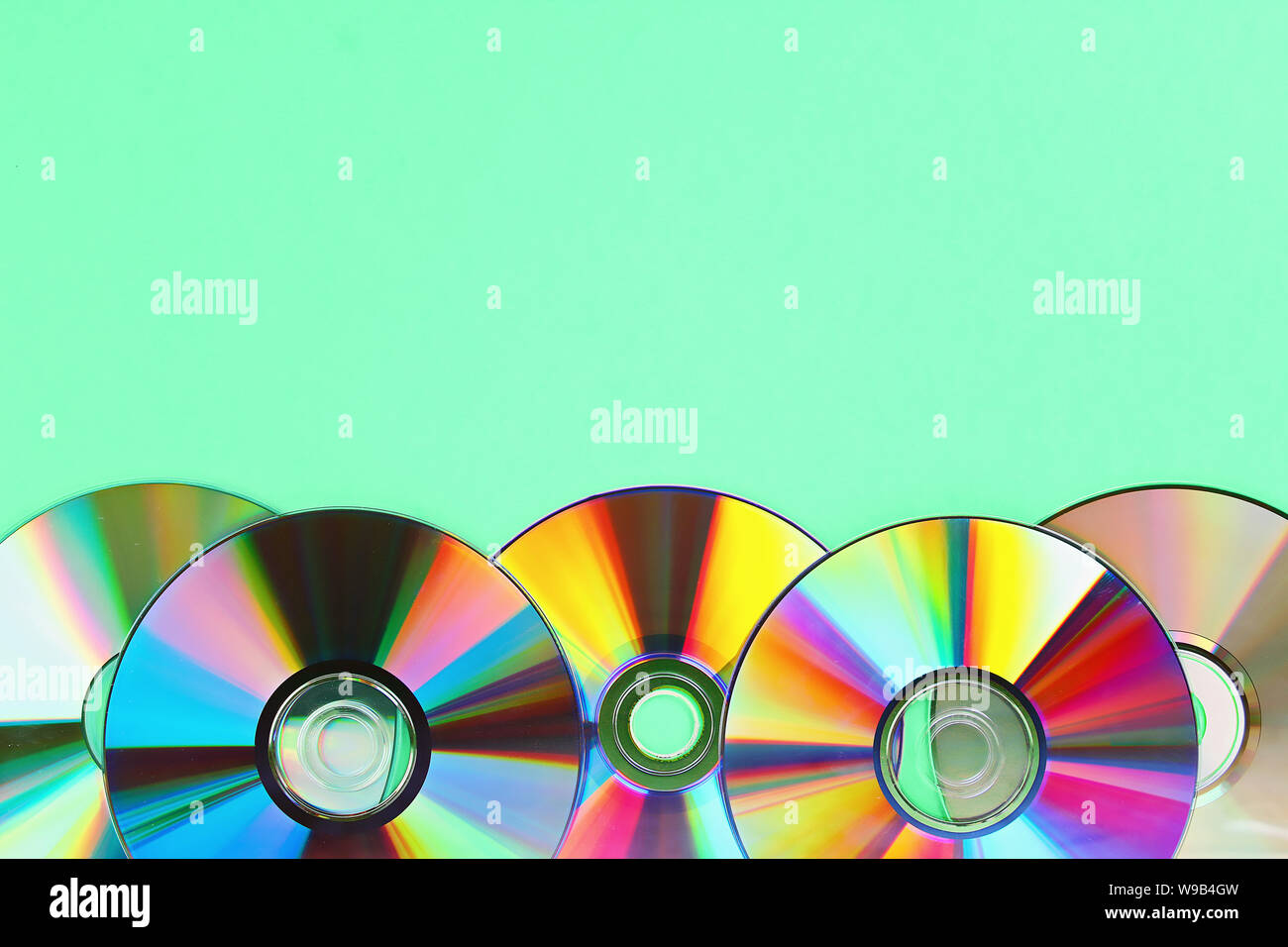 Piles of old and dirty CDs,DVD on pastel mint background. Used and ...