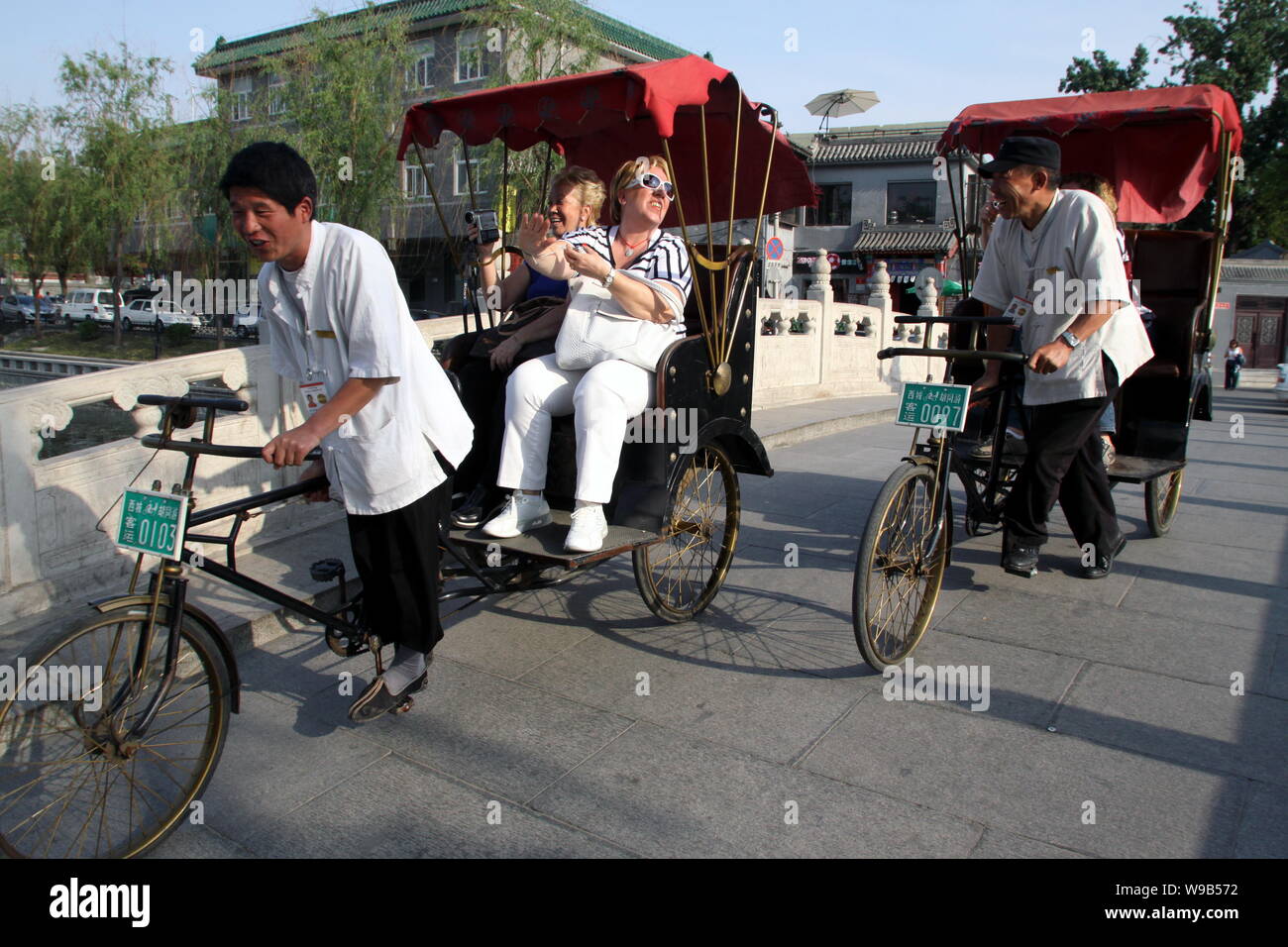 --FILE-- Chinese draymen pull their rickshaws carrying foreign tourists ...