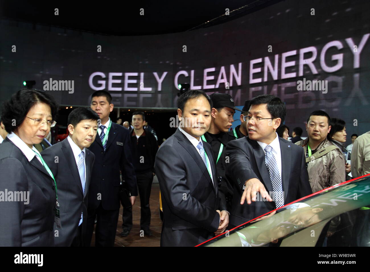 Li Shufu (C), Chairman and CEO of Geely Holding Group, visits the stand ...