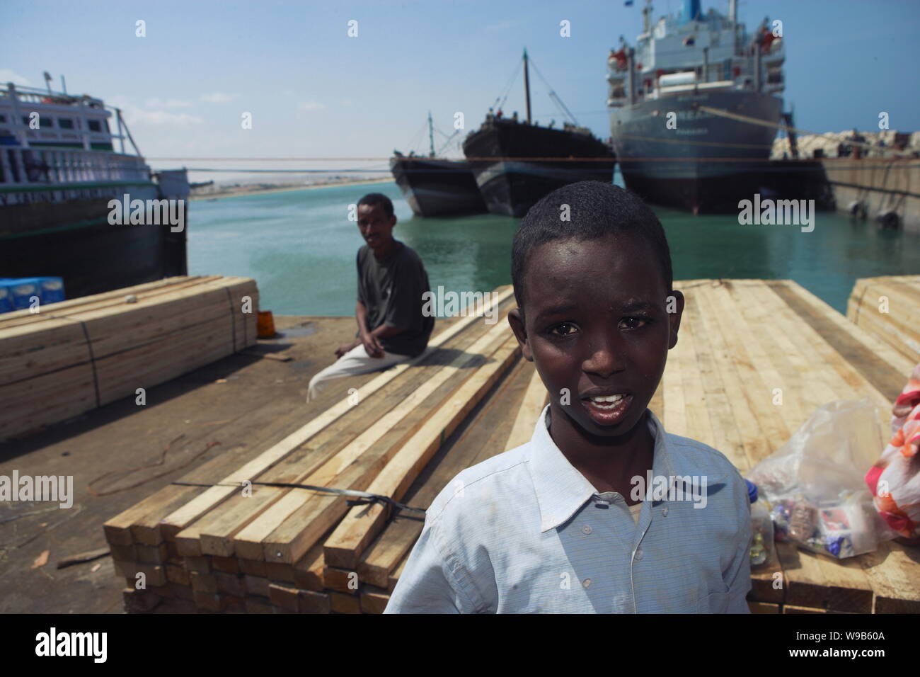 Somali workers pose next to wood products at the harbor in Bosaso ...