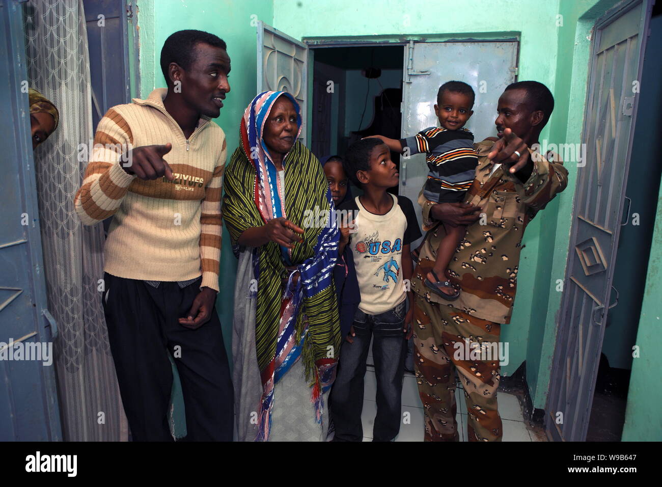 A Somali mercenary, right, and his family members pose for photos at ...