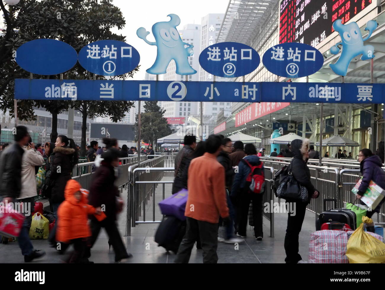 Passengers line up to enter the Shanghai Railway Station in Shanghai ...