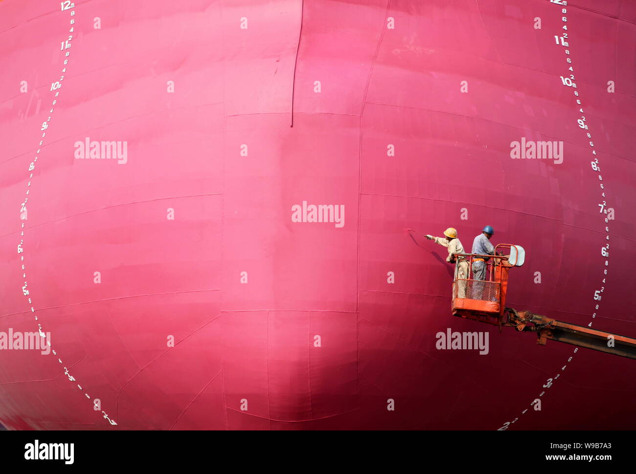 Chinese workers paint a bulk cargo ship at the Jinling Shipyard of ...