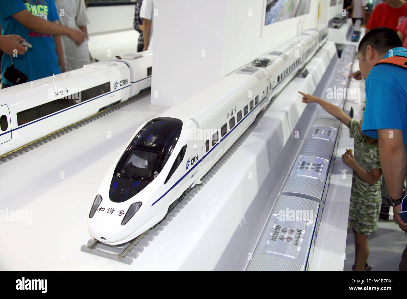 Chinese visitors look at model CRH (China Railway High-speed) trains ...