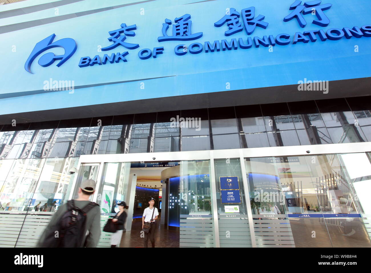 --FILE--Visitors walk past a branch of Bank of Communications (BoCom ...