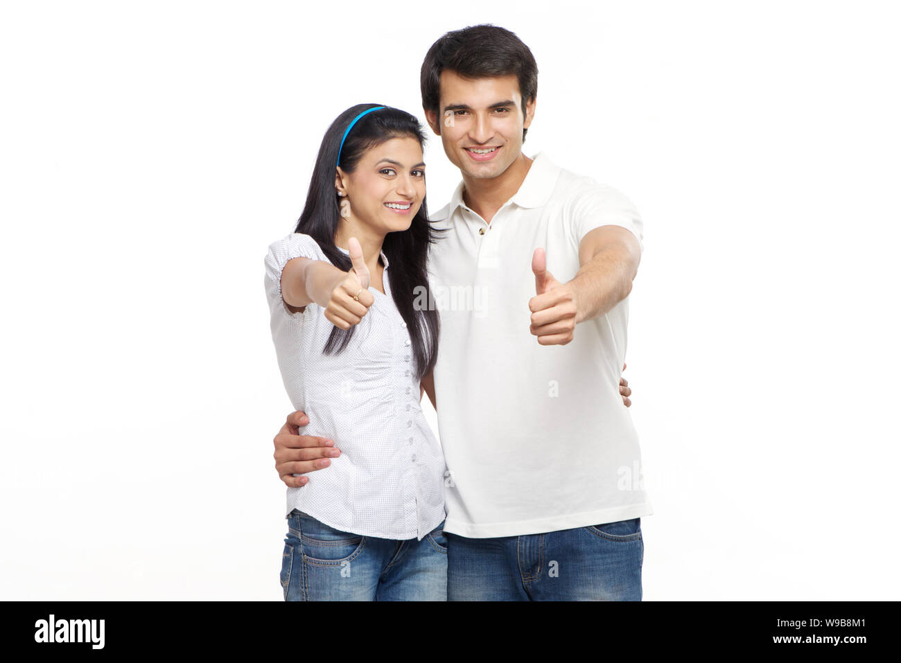 Young couple showing thumbs up sign and smiling Stock Photo - Alamy