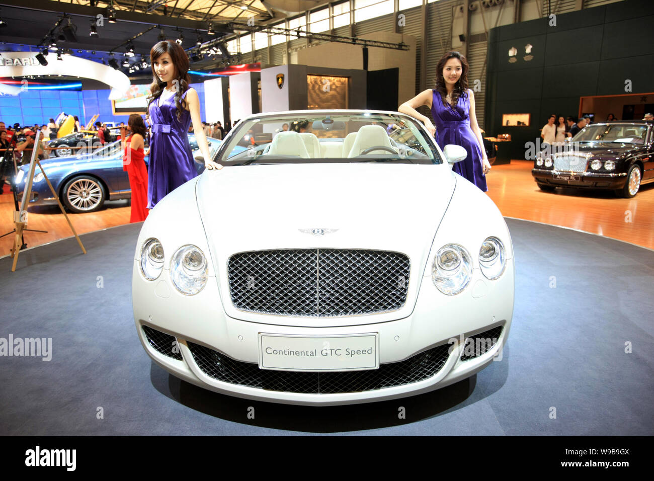 --FILE--Chinese models pose next to a Bentley Continental GTC Speed at ...