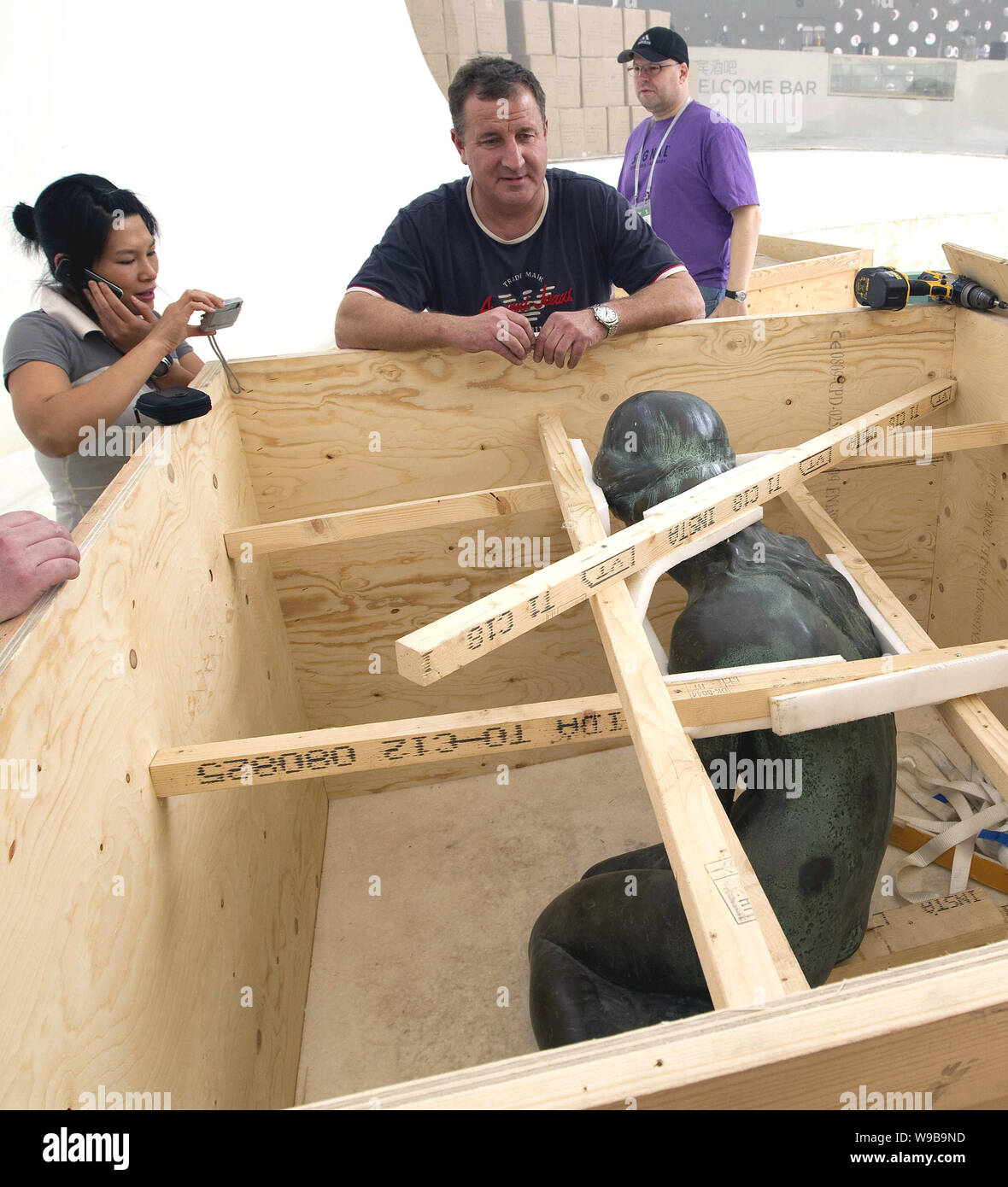 A staff of the Denmark Pavilion takes photos of the Little Mermaid ...