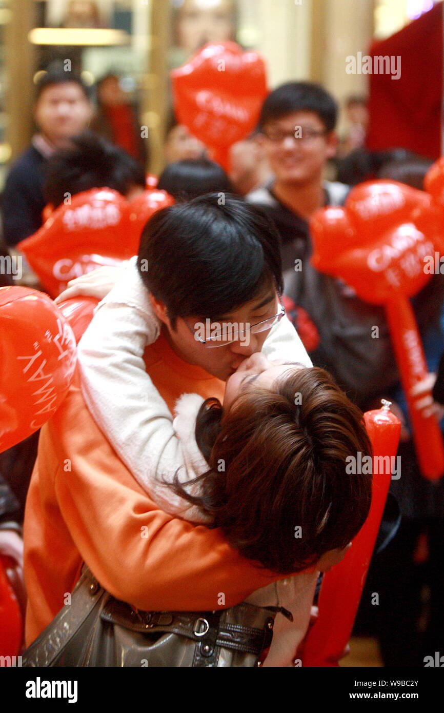 Couples of young Chinese lovers kiss during a campaign to mark the upcoming Valentines Day at a ...