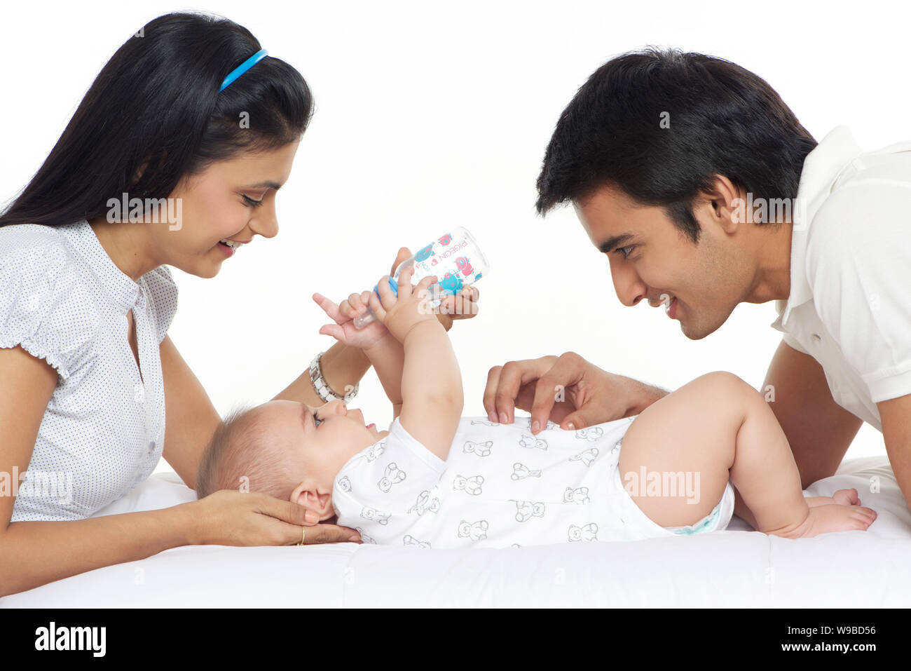 Parents feeding water to their baby Stock Photo - Alamy
