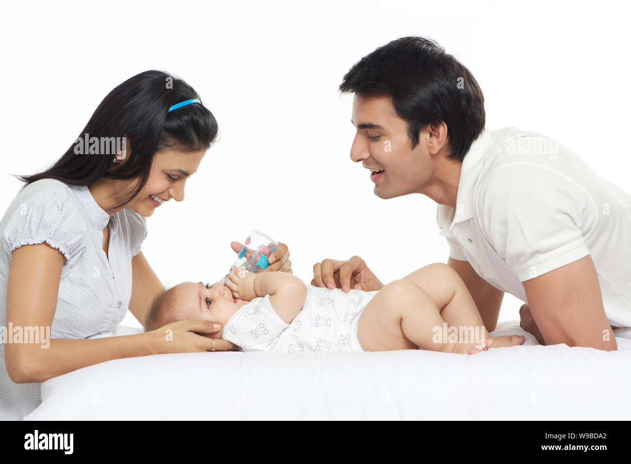 Parents feeding water to their baby Stock Photo - Alamy