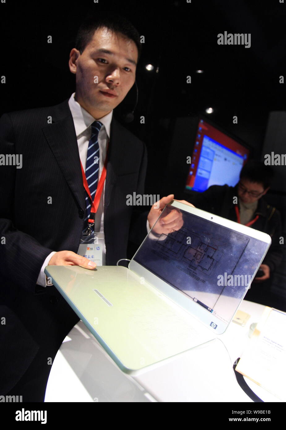 A Chinese staff shows an HP laptop computer with a transparent screen ...