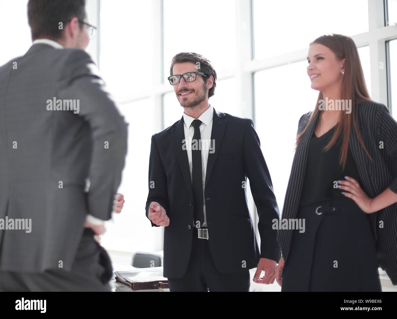 employees discuss something standing in the office Stock Photo - Alamy