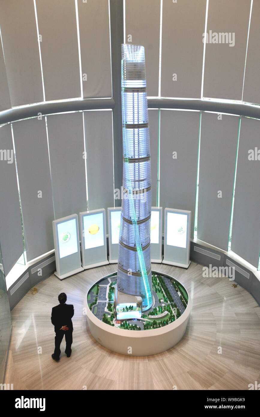 A Chinese man looks at a model of Shanghai Tower at an exhibition hall ...