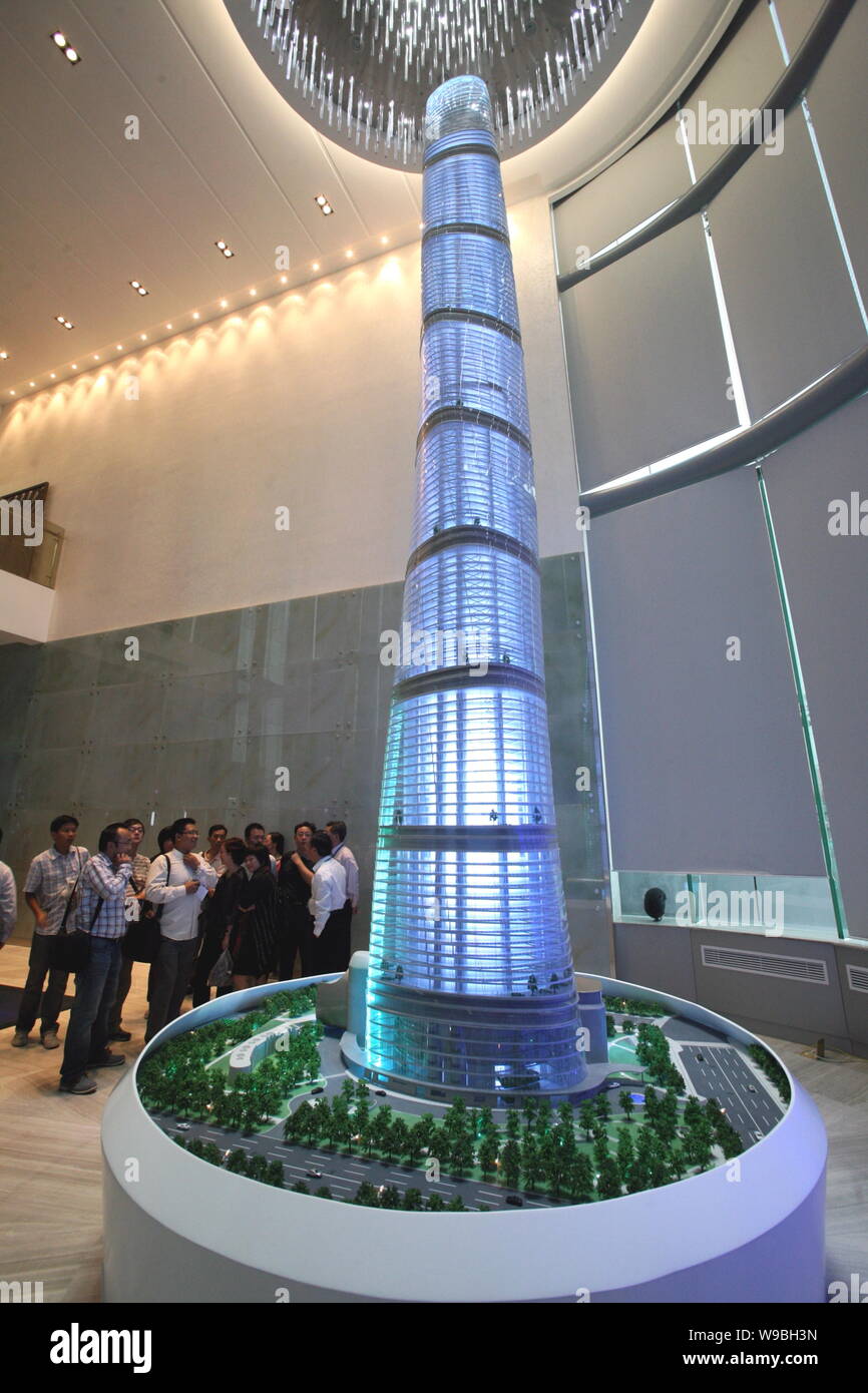 Visitors look at a model of Shanghai Tower at an exhibition hall of ...