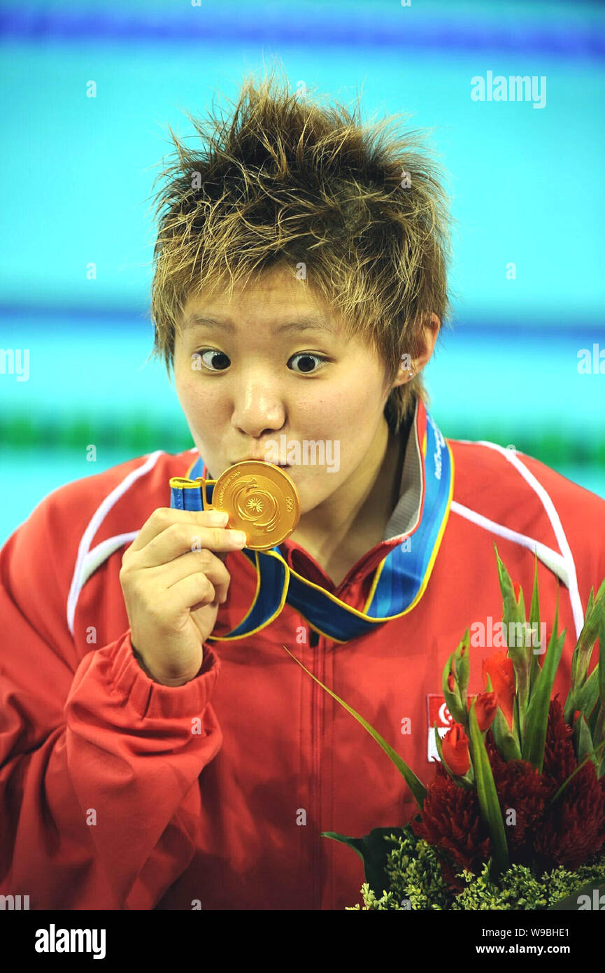 Tao Li of Singapore shows her gold medal during the award ceremony for ...