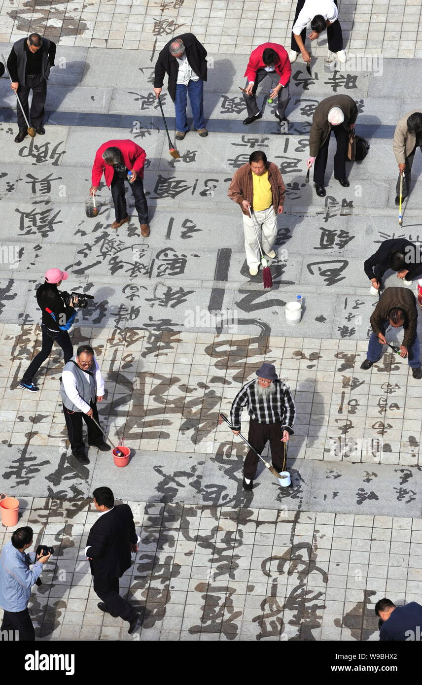 Local Chinese residents write Chinese characters with long brushes ...