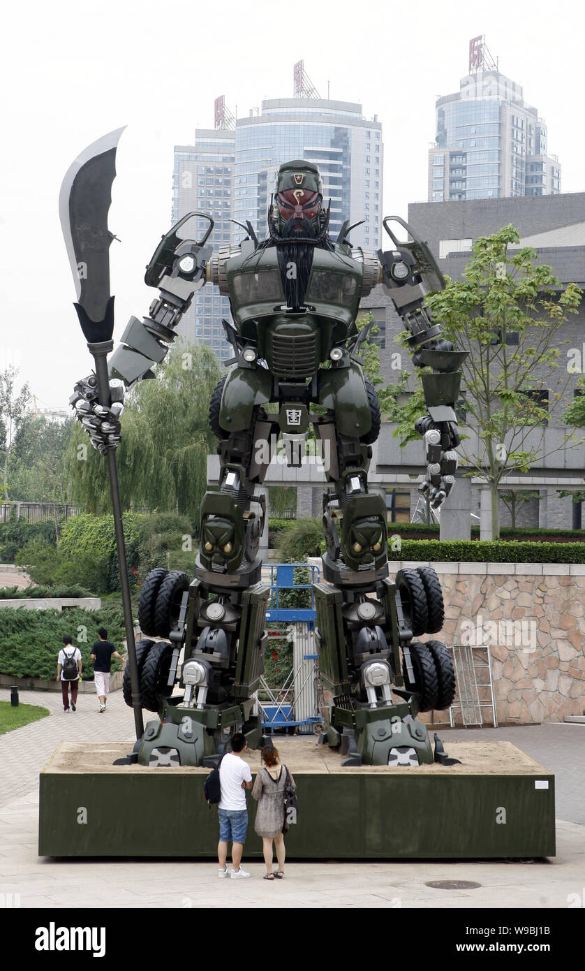 Chinese young people look at the Transformer statue in the shape of ...