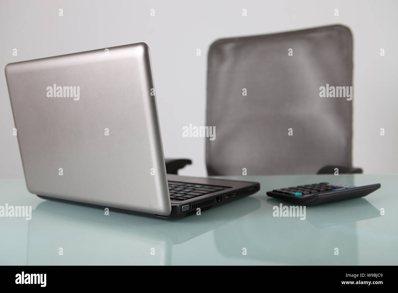 Laptop and calculator on an office desk Stock Photo - Alamy