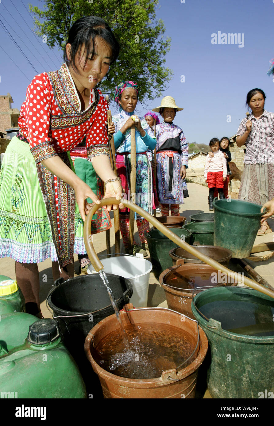 Chinese villagers fill their buckets with water distributed by local ...