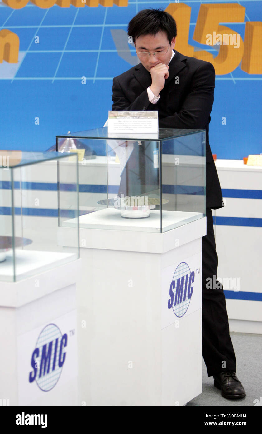 --FILE--A Chinese visitor looks at a wafer at the booth of SMIC ...