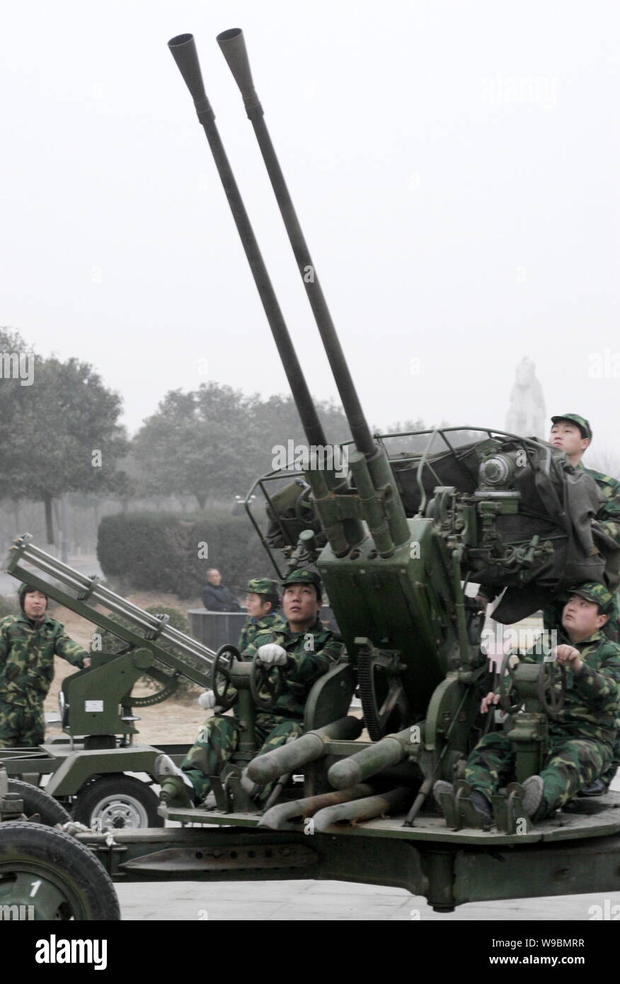 Chinese meteorological department workers prepare to fire artillery ...