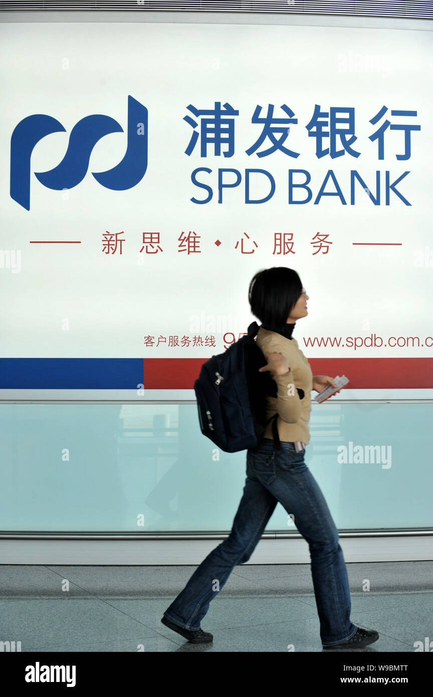 --FILE--A Chinese passenger walks past an advertisement for SPD Bank ...