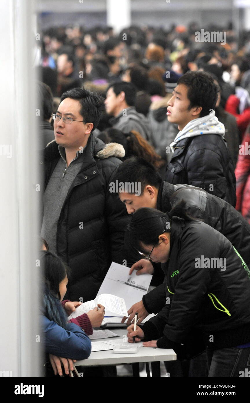 Chinese job seekers crowd booths at a job fair in Shenyang city ...