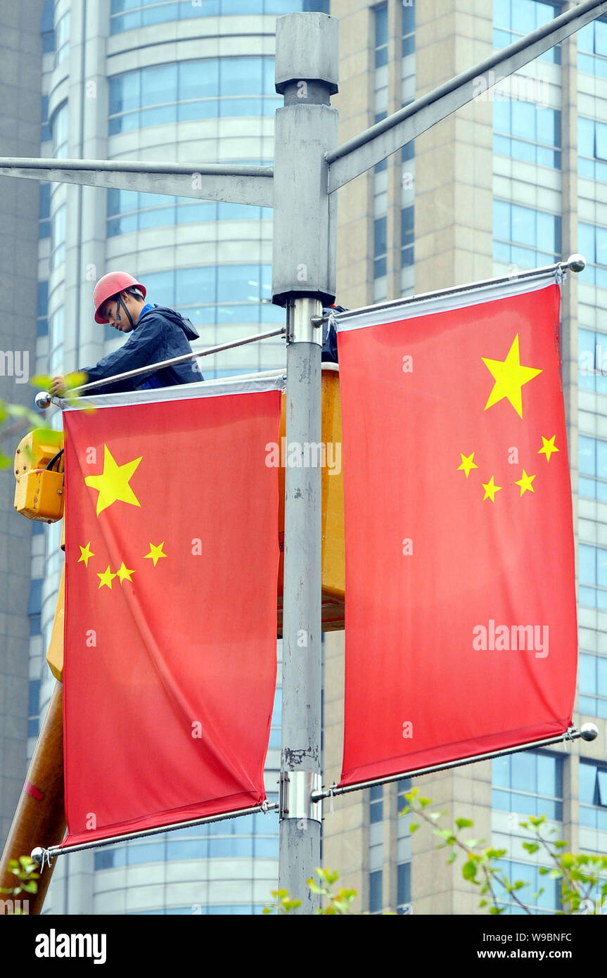 Chinese workers hang up Chinese national flags on a lamppost in ...