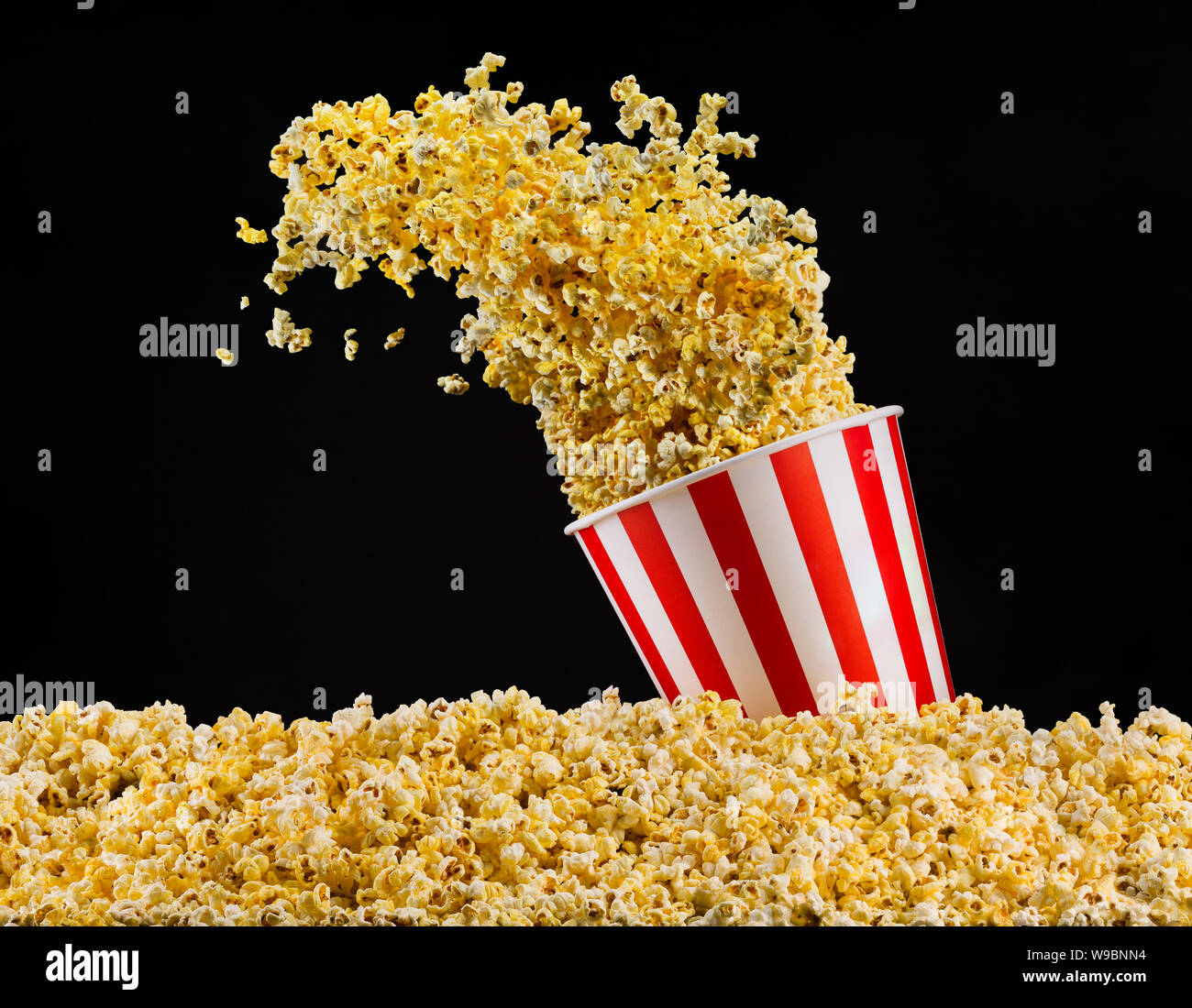 Flying popcorn from striped bucket isolated on black background Stock ...
