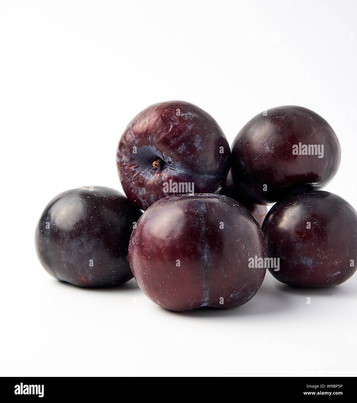 bunch of ripe fresh blue round plums on a white background, summer ...