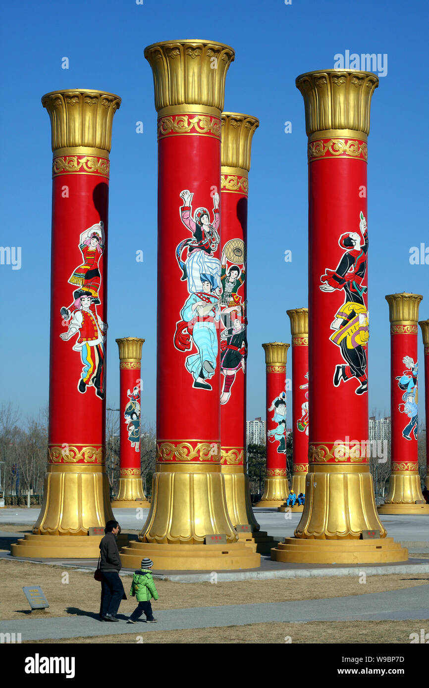 Chinese residents walk past the Columns of National Unity in the ...