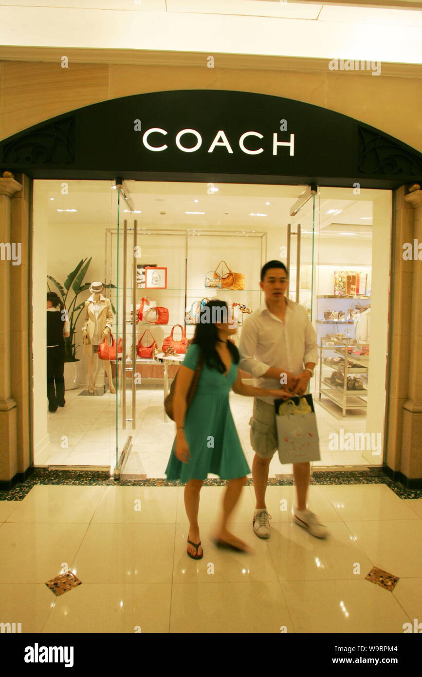 --FILE--Two customers walk out from a Coach boutique at a shopping mall ...