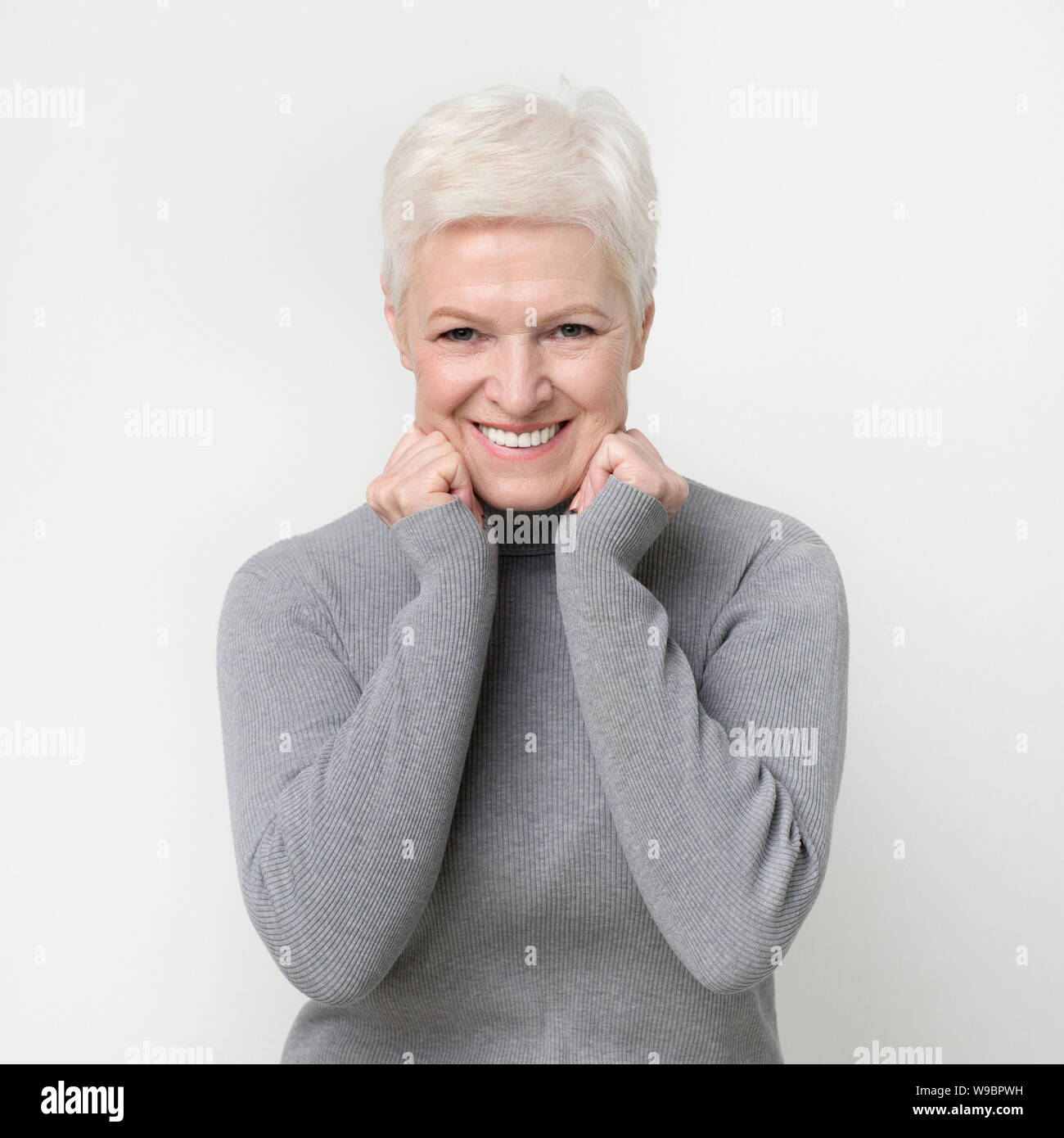 Lovely senior lady feeling shy posing at camera Stock Photo - Alamy