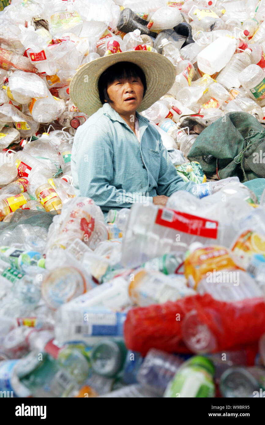--FILE--A Chinese worker cleans up waste plastic bottles at a recycling ...