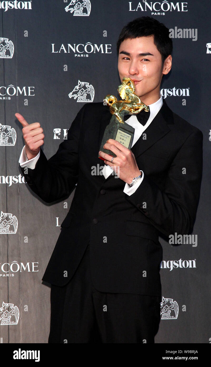 Taiwanese actor Ethan Ruan kisses the trophy of the Best Actor at the ...