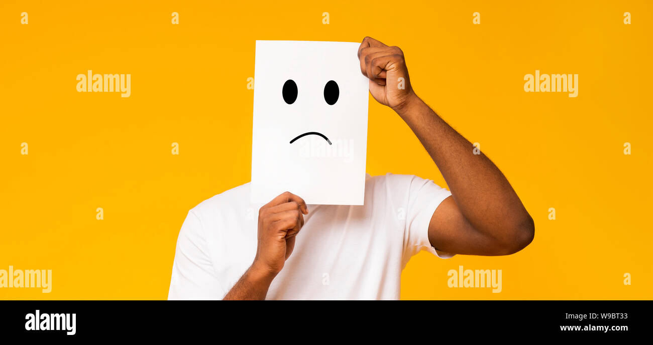 Black man holding paper with sad face Stock Photo - Alamy
