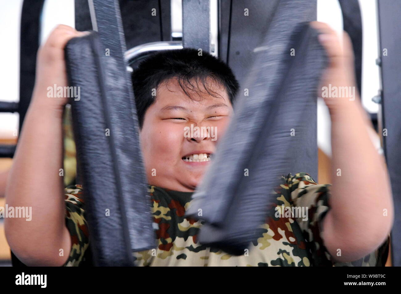 An obese Chinese child exercises in a fitness center during a military ...