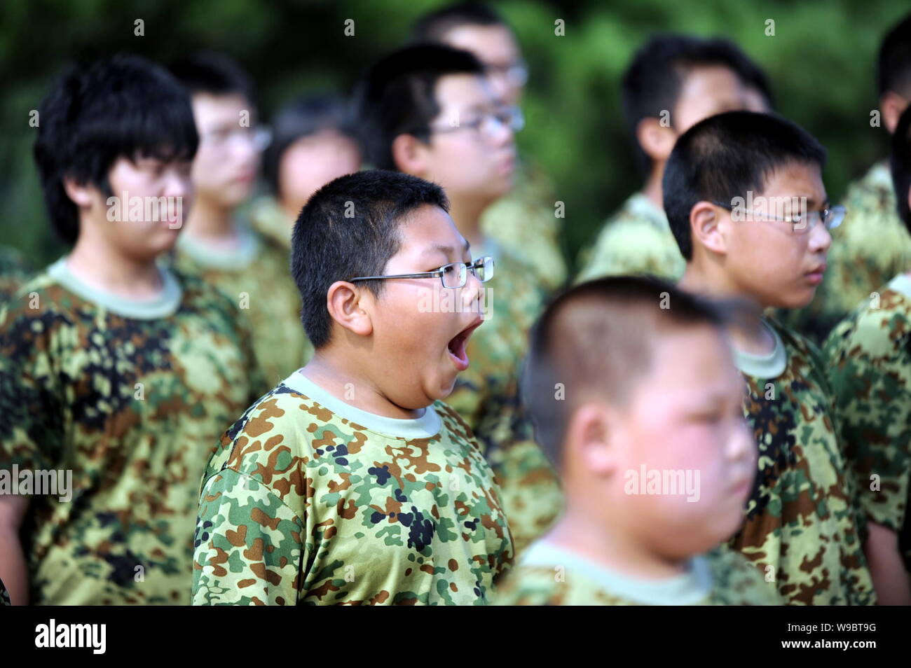 An obese Chinese child yawns amid others at an exercise during a ...