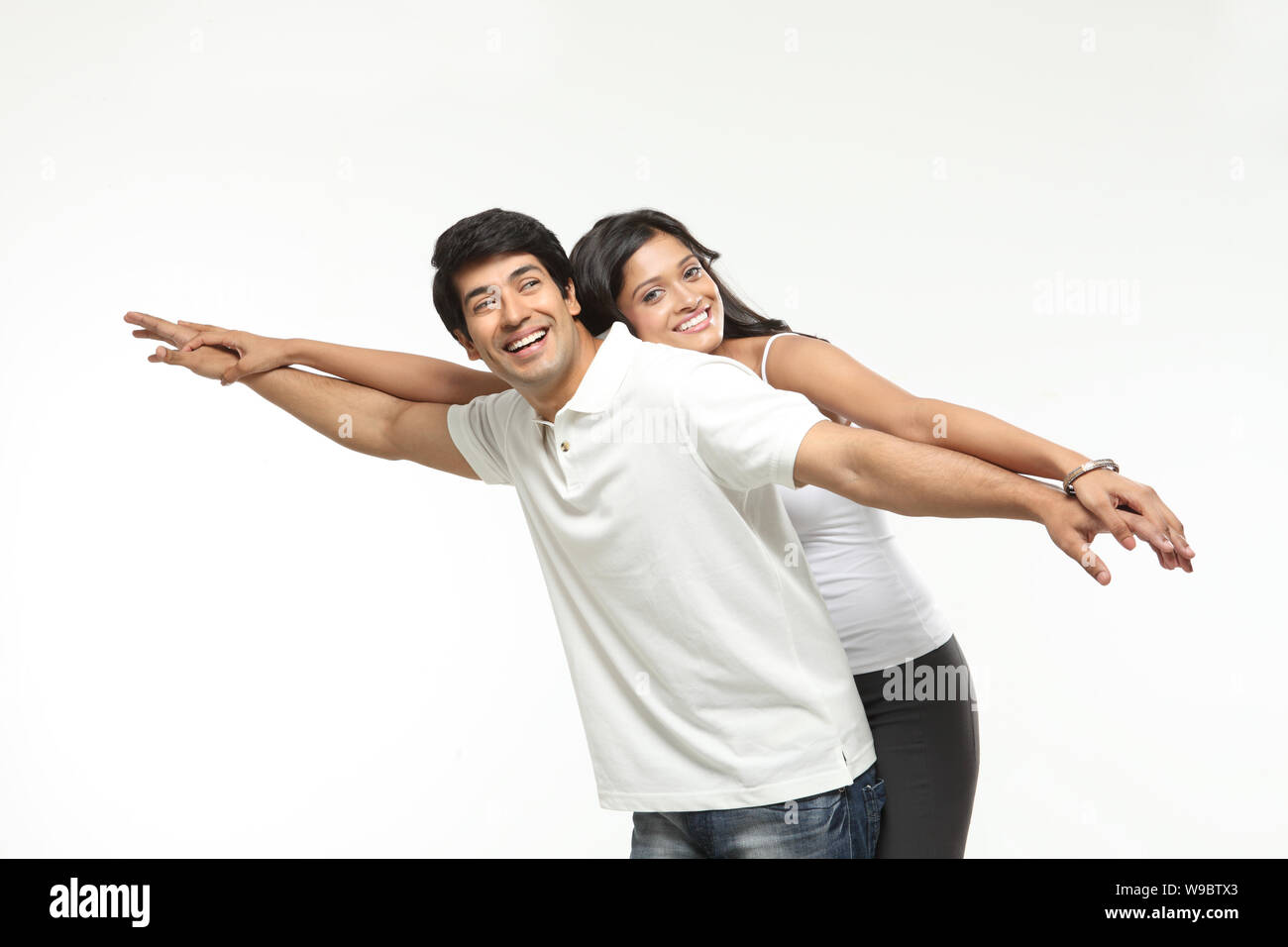 Young couple standing with arm outstretched Stock Photo - Alamy