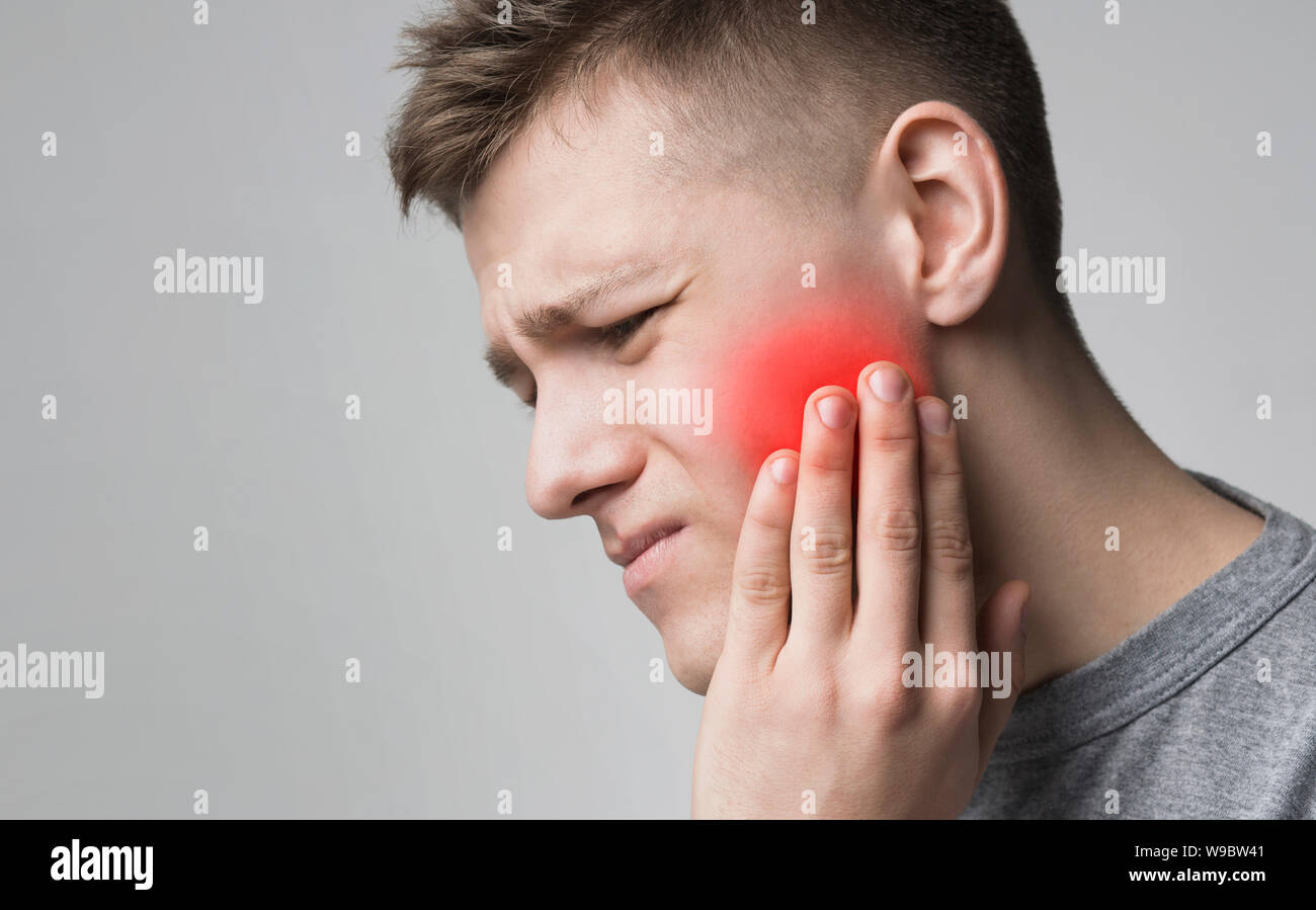 Man suffering from toothache, touching inflamed cheek Stock Photo - Alamy