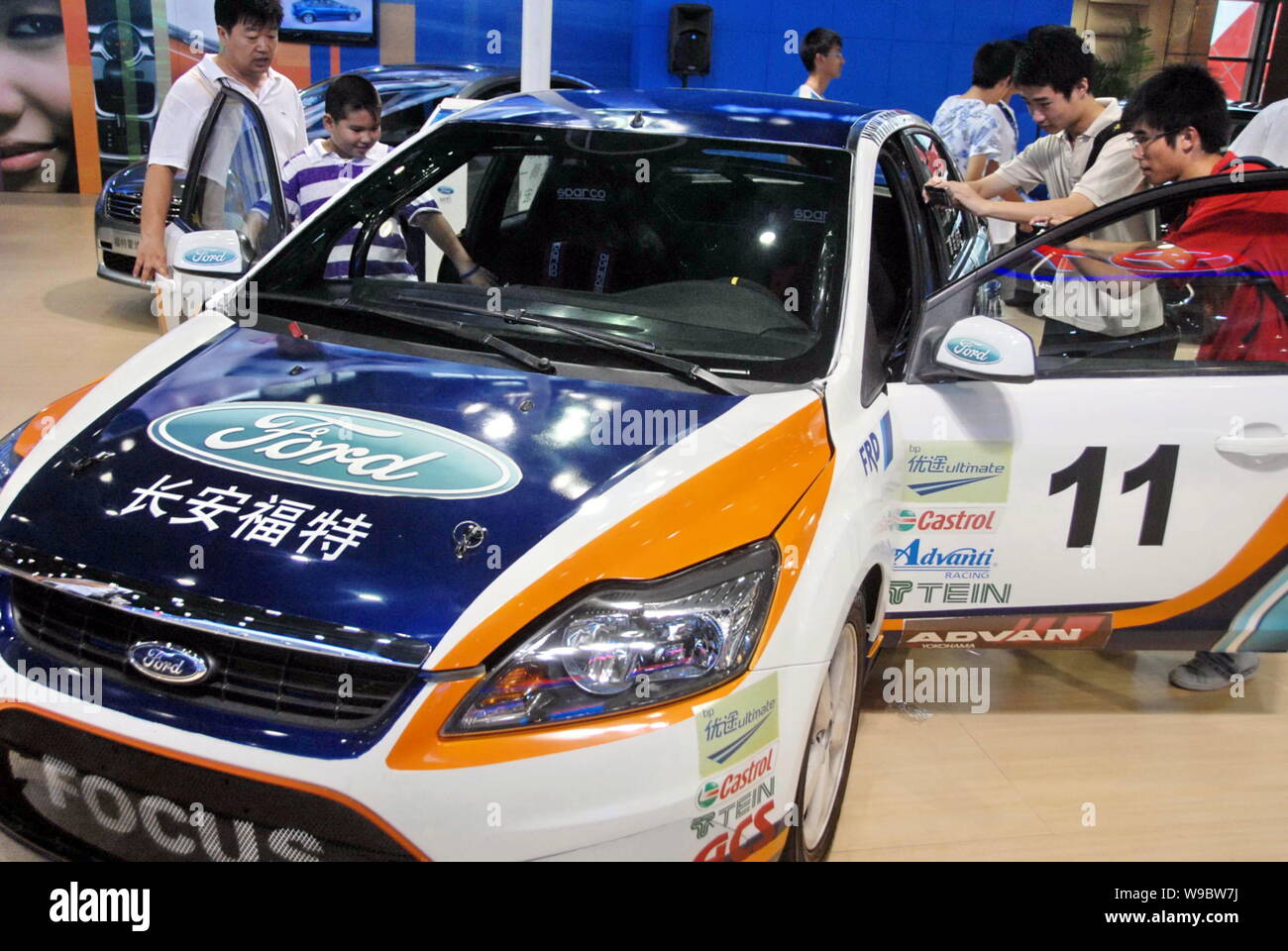 --FILE--Chinese visitors look at a Ford Focus, manufactured by ChangAn ...