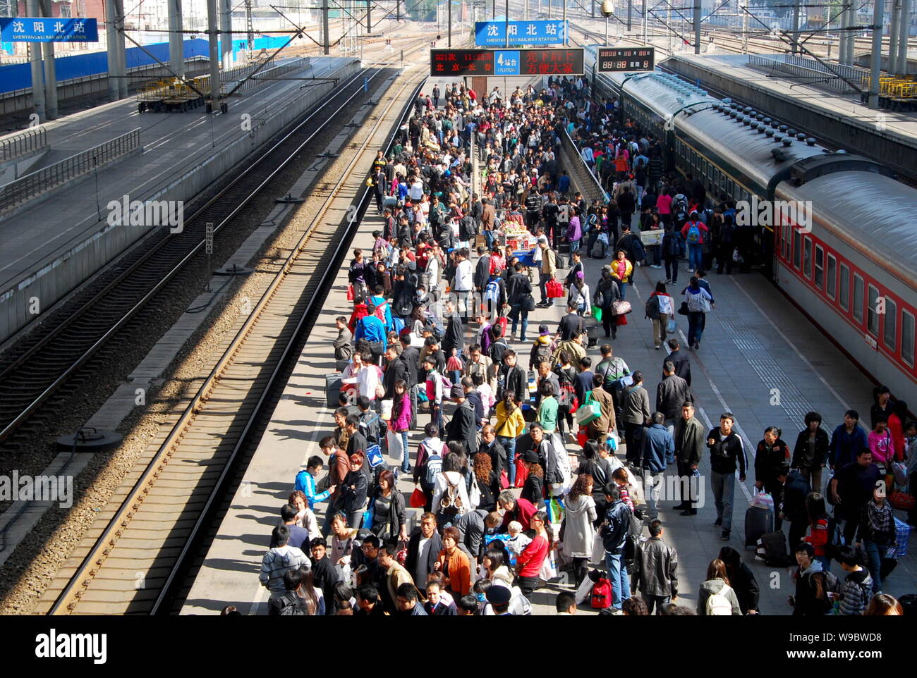Crowds of Chinese passengers wait for a train on the platform at the ...