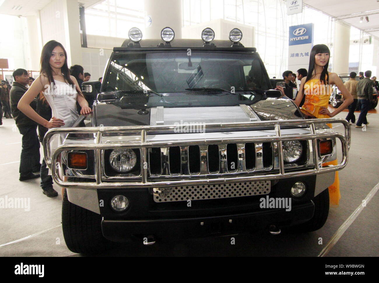 --FILE--Chinese models pose with a Hummer SUV at a car show in Changsha ...