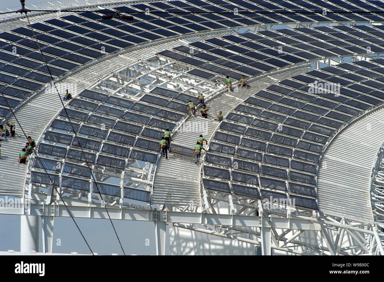Chinese workers install solar heat pipe collectors on the rooftop of ...